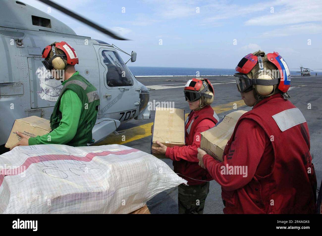 US Navy Sailors assigned to Carrier Air Wing Two (CVW-2) load boxes of ...