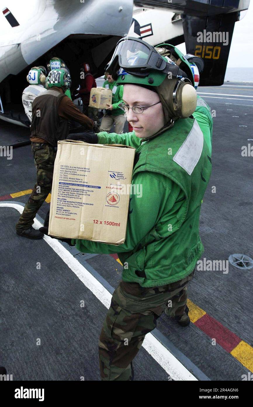 US Navy Sailors assigned to Carrier Air Wing Two (CVW-2) off load boxes ...