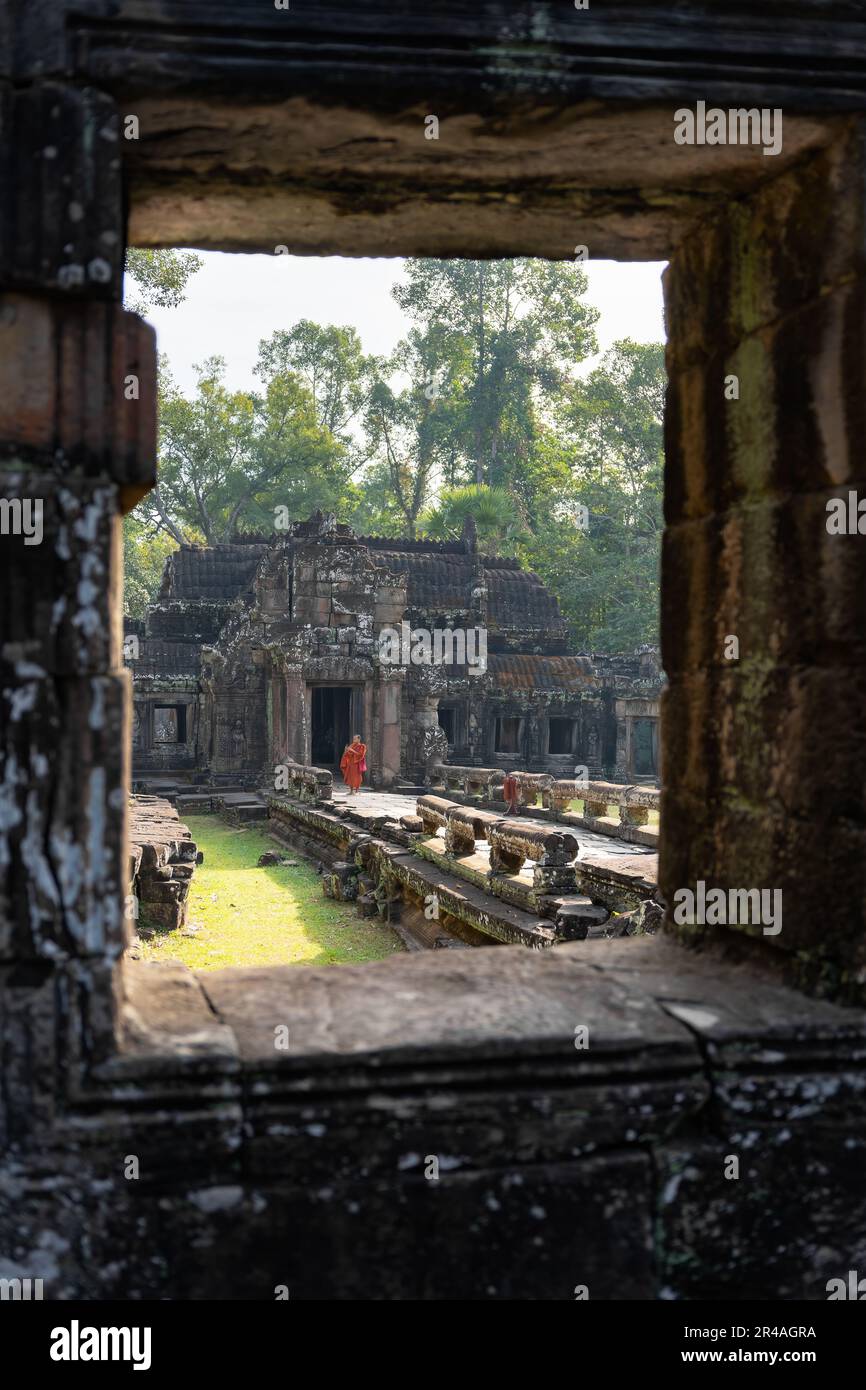 A Vertical shot of a monk standing among the ruins of a temple, seen ...
