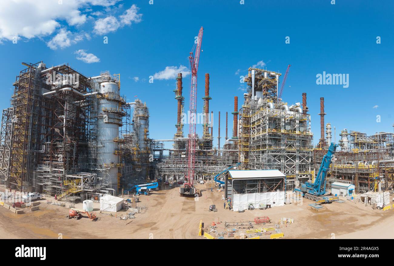 A sun-drenched skyline featuring a sprawling industrial complex with ...
