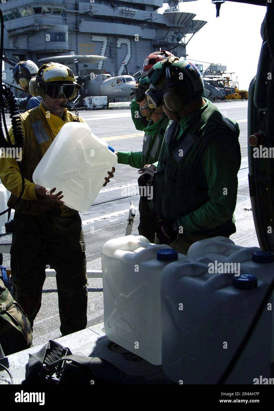 US Navy Flight deck personnel load jugs of purified drinking water onto ...