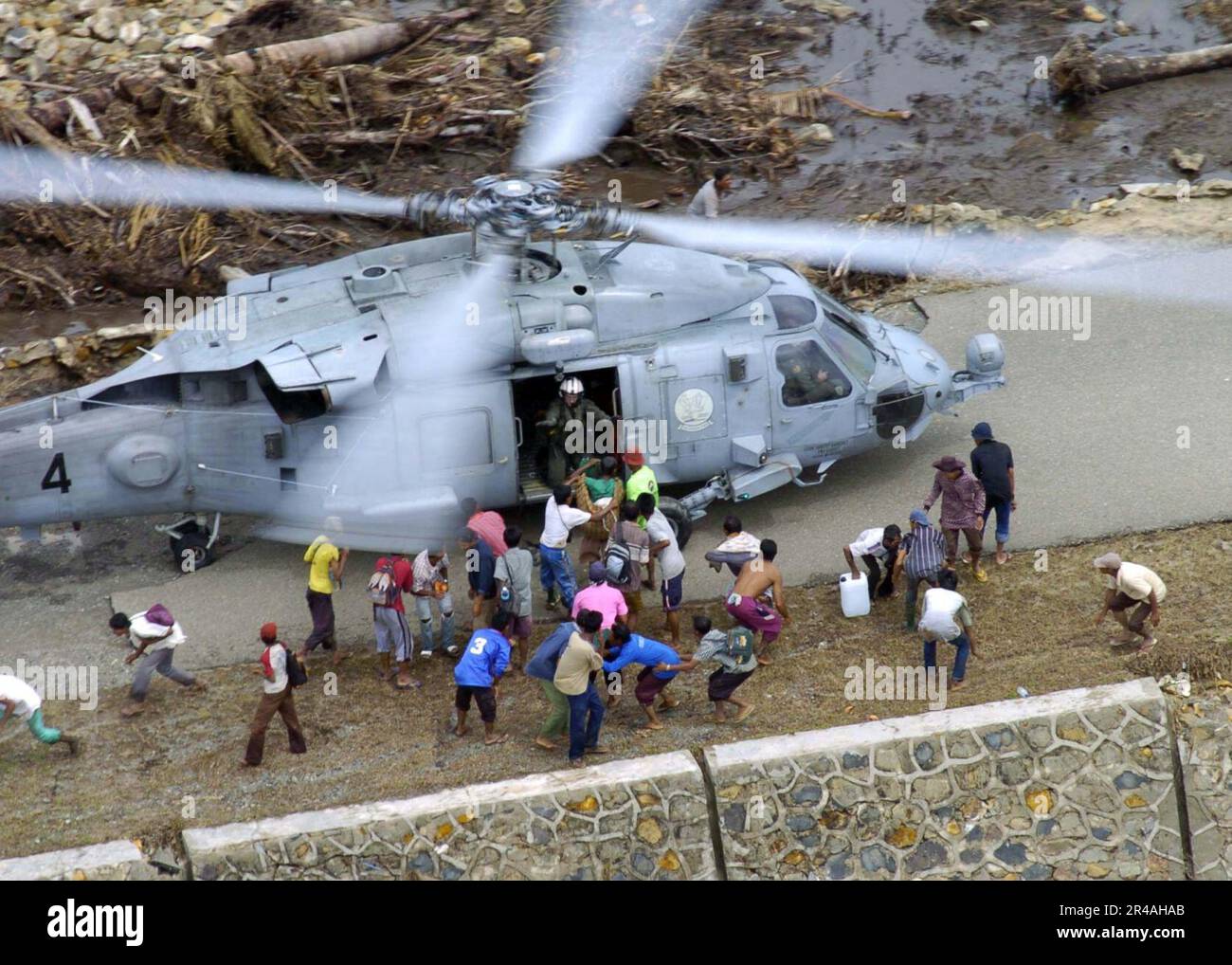 US Navy Indonesians rush to an HH-60H Seahawk helicopter assigned to ...