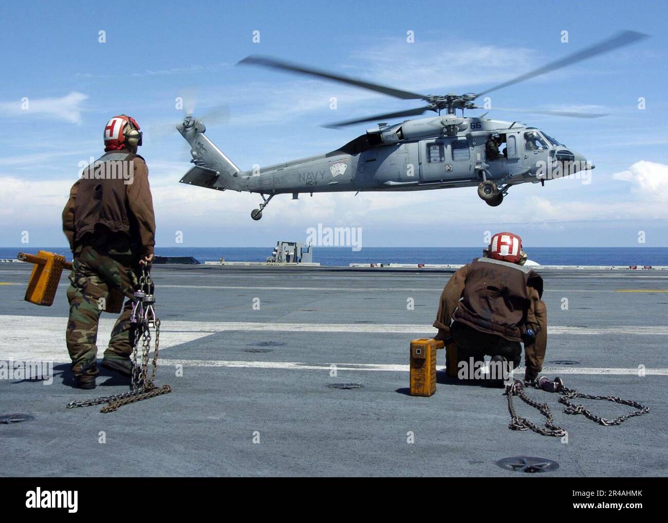 US Navy Line Division personnel prepare to chock and chain an MH-60S ...