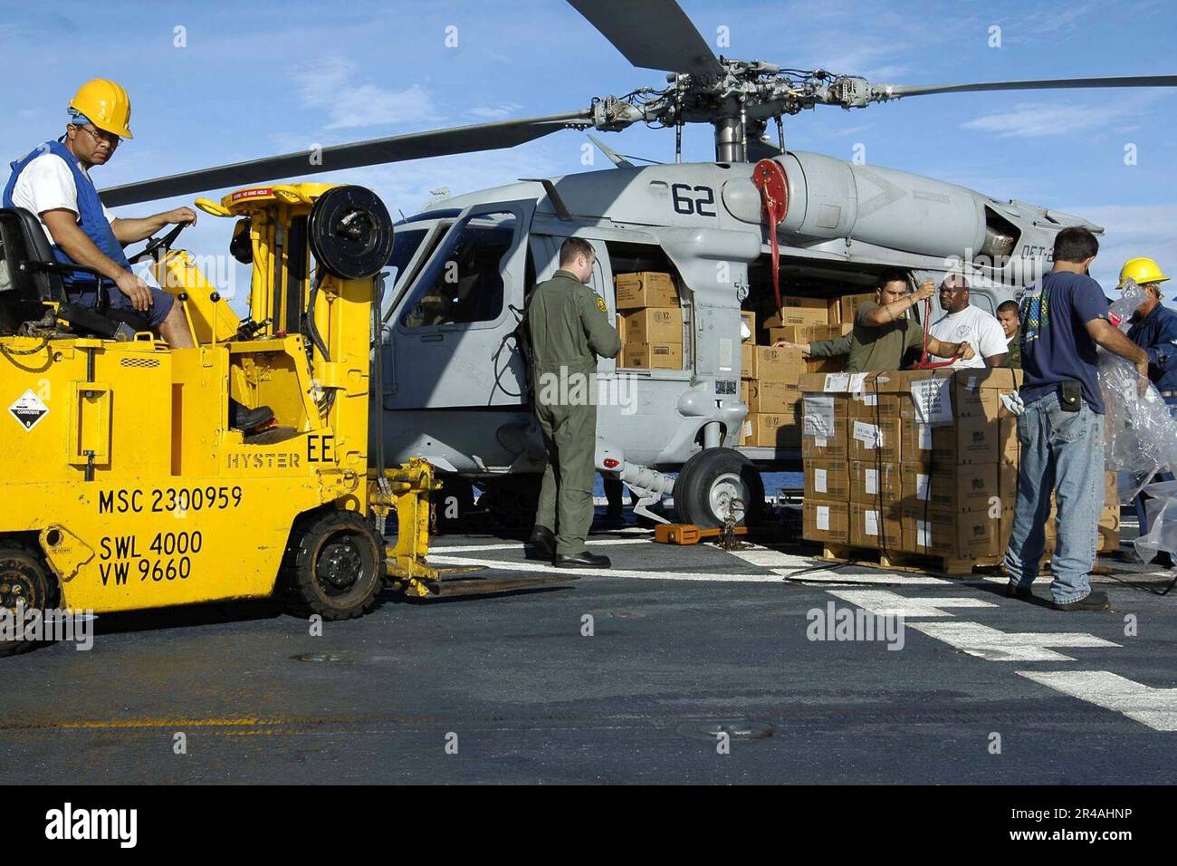 US Navy Merchant Marine Sailors load a MH-60S Knighthawk helicopter ...