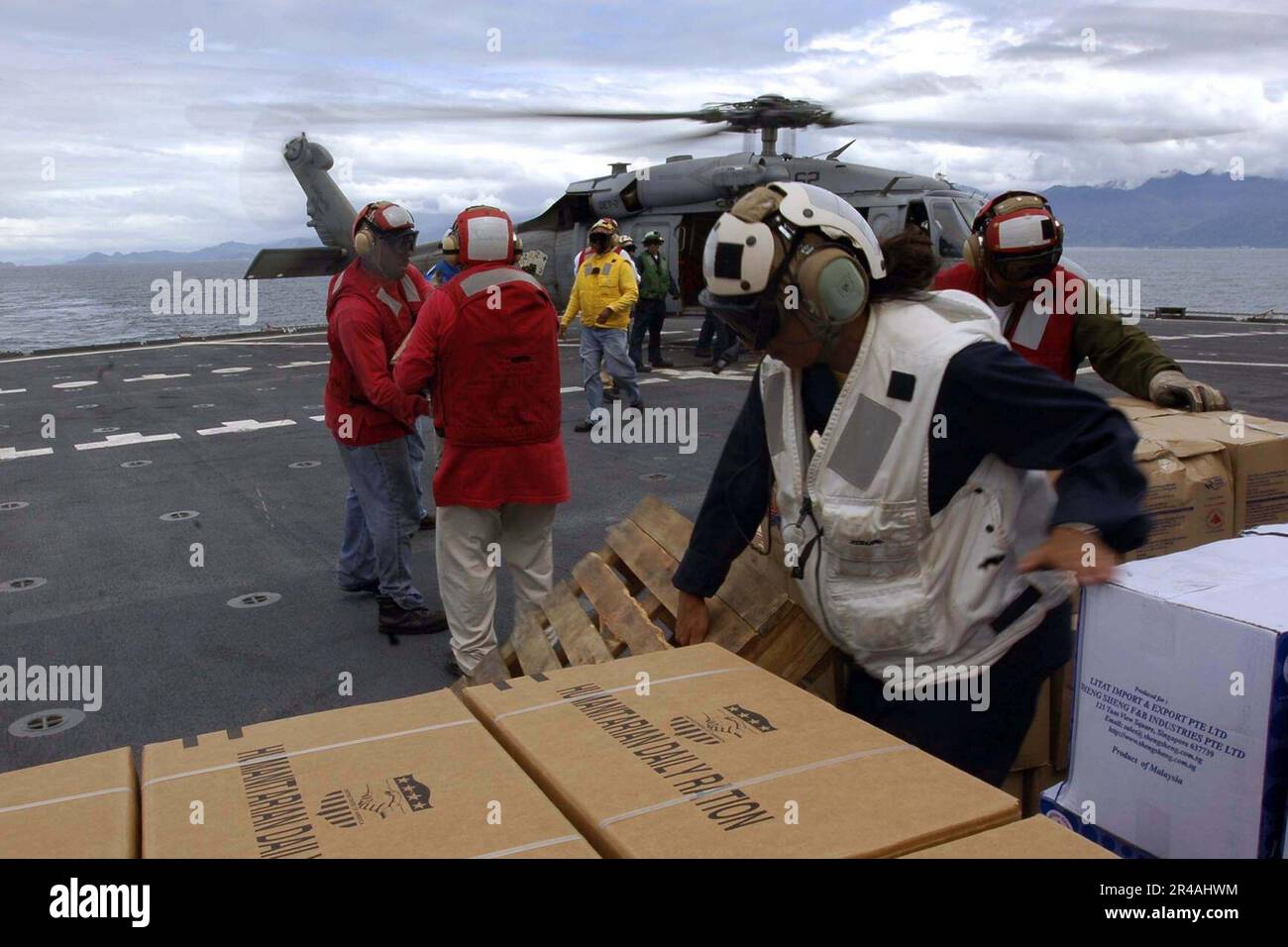 US Navy Merchant Marine Sailors load a MH-60S Knighthawk helicopter ...