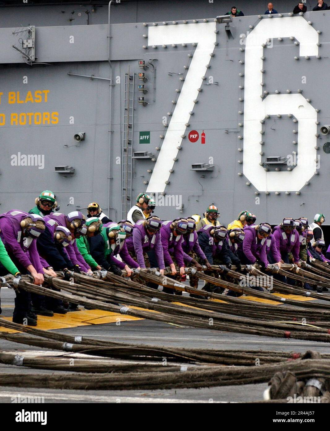 US Navy Flight deck personnel stretch-out the emergency-landing ...