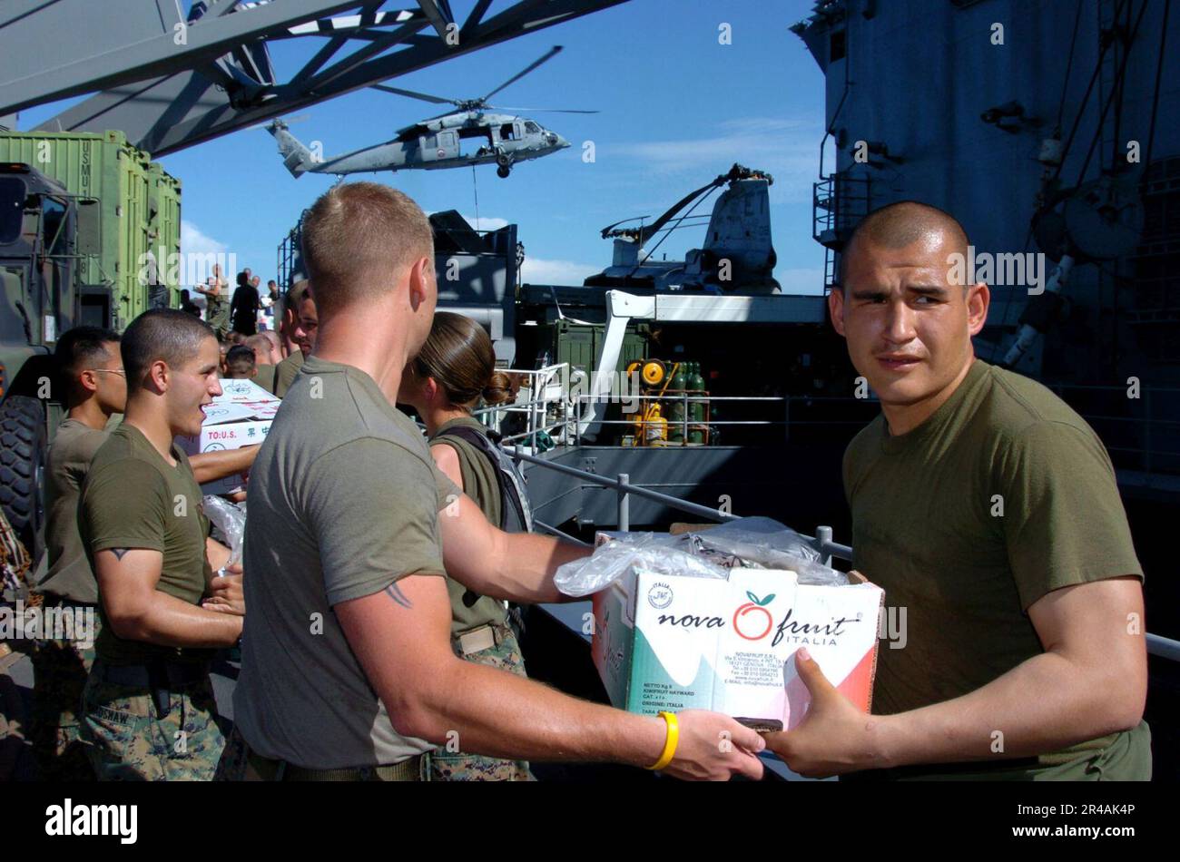 US Navy Sailors and Marines store supplies received during a vertical ...