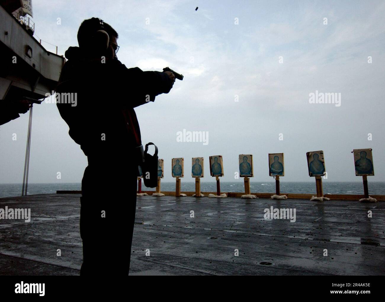 US Navy An empty shell ejects out of a 9mm pistol as a Sailor ...