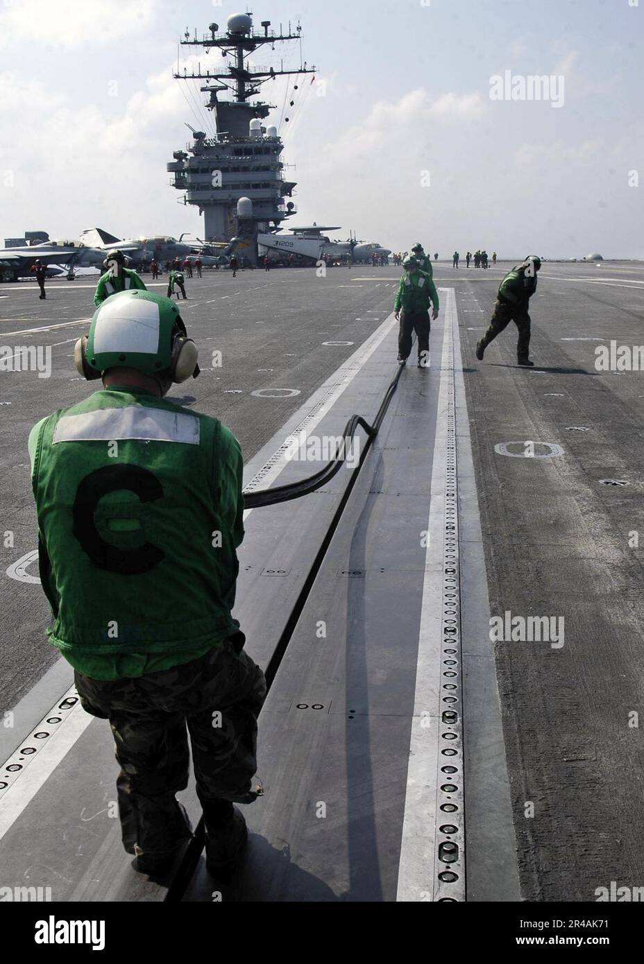 US Navy Sailors from the Air Department place a rubber seal into ...