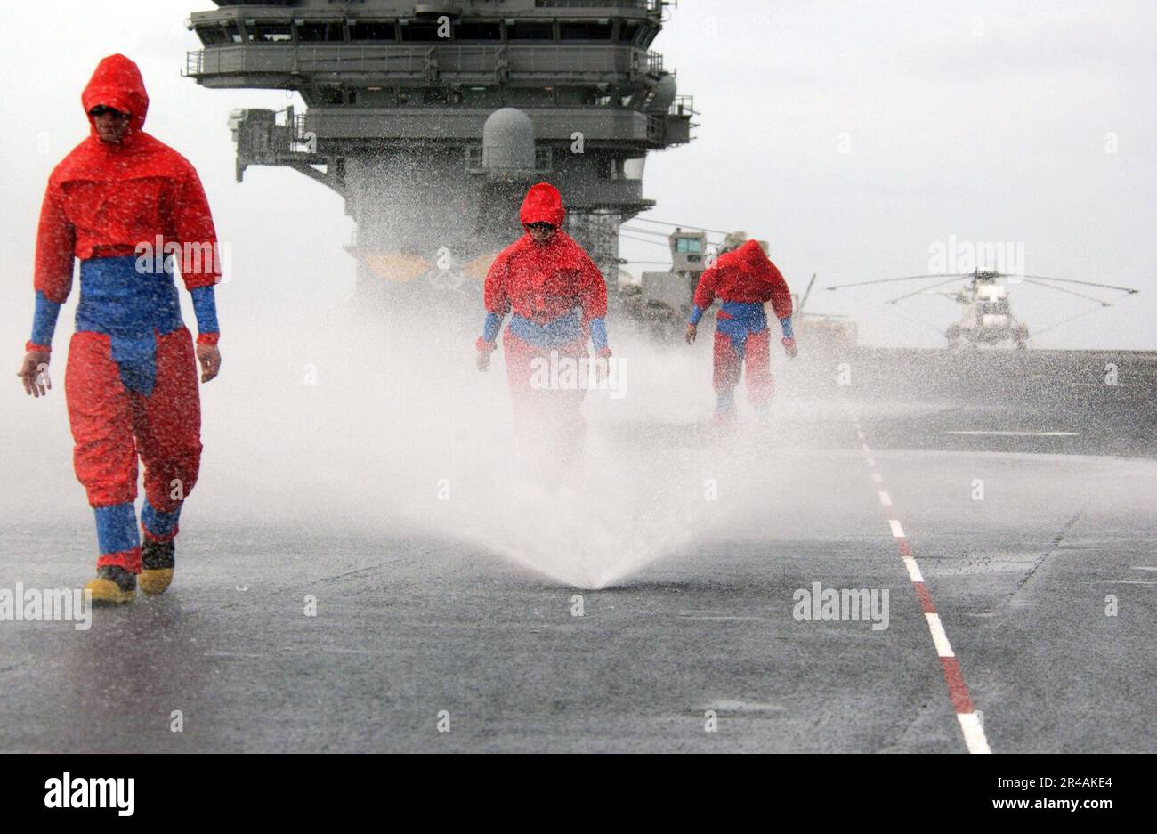 US Navy Flight deck personnel check the sprinkler system on the flight ...