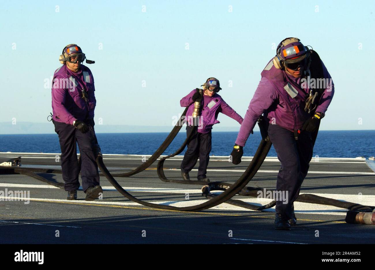 US Navy Aviation Boatswain's Mates return a fuel hose to its proper ...