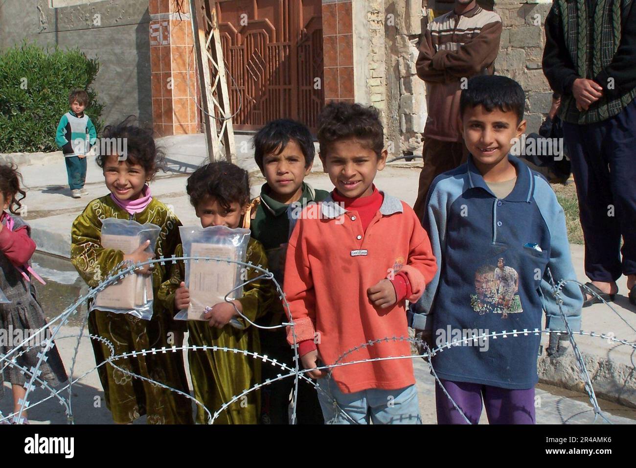 US Navy Iraqi children stand outside a project site, having received ...