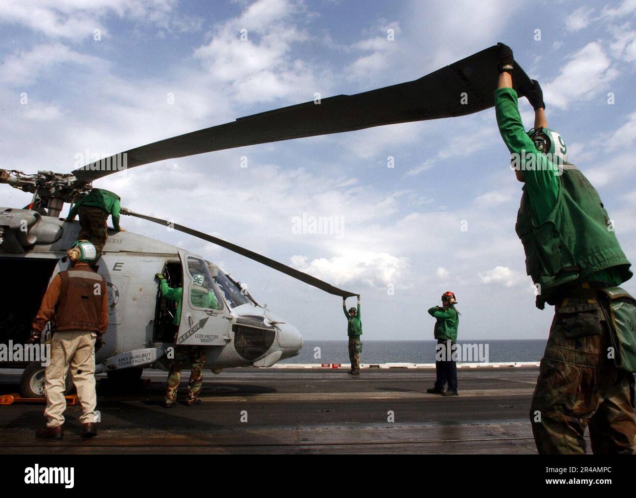 US Navy Sailors prepare to fold down the blades of an SH-60F Seahawk ...