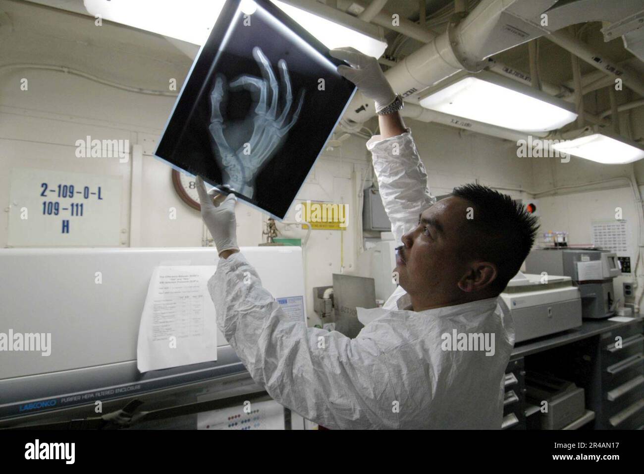 US Navy Hospital Corpsman 1st Class looks at an X-ray of a broken ...