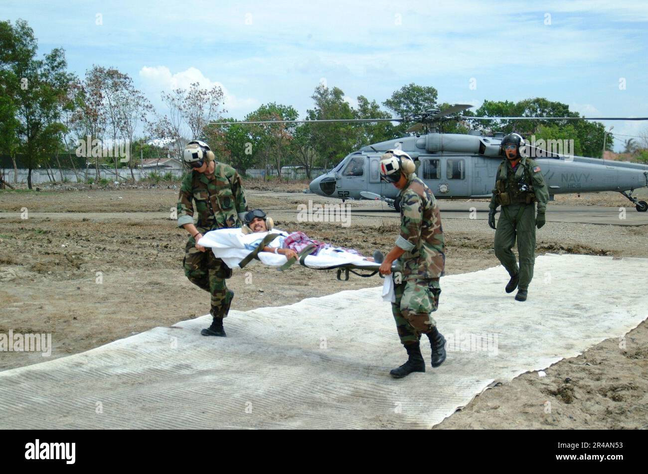 US Navy Two U.S. Navy Sailors carry an injured Indonesian man on a ...