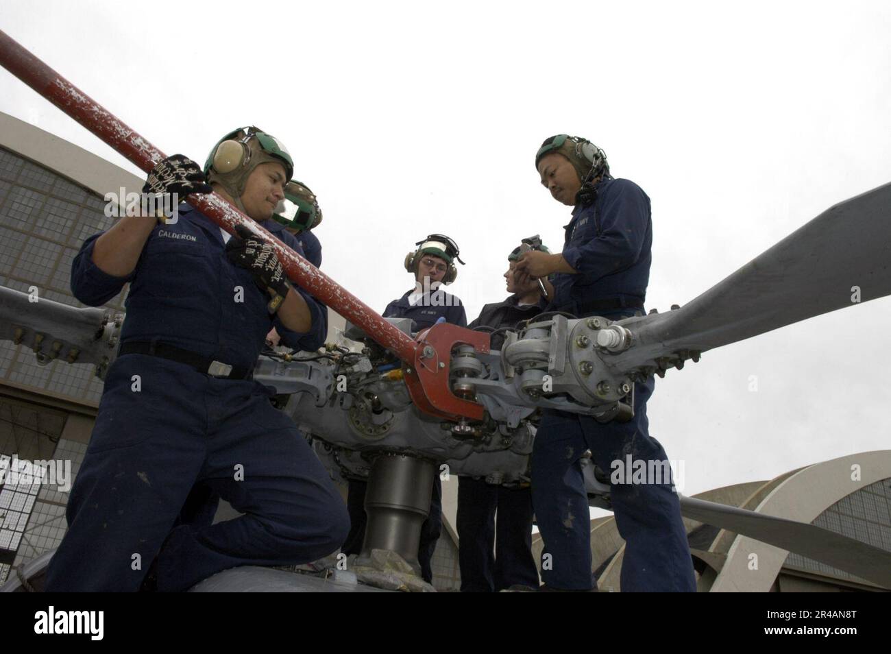 US Navy Sailors work together to reconnect wires and make adjustments ...