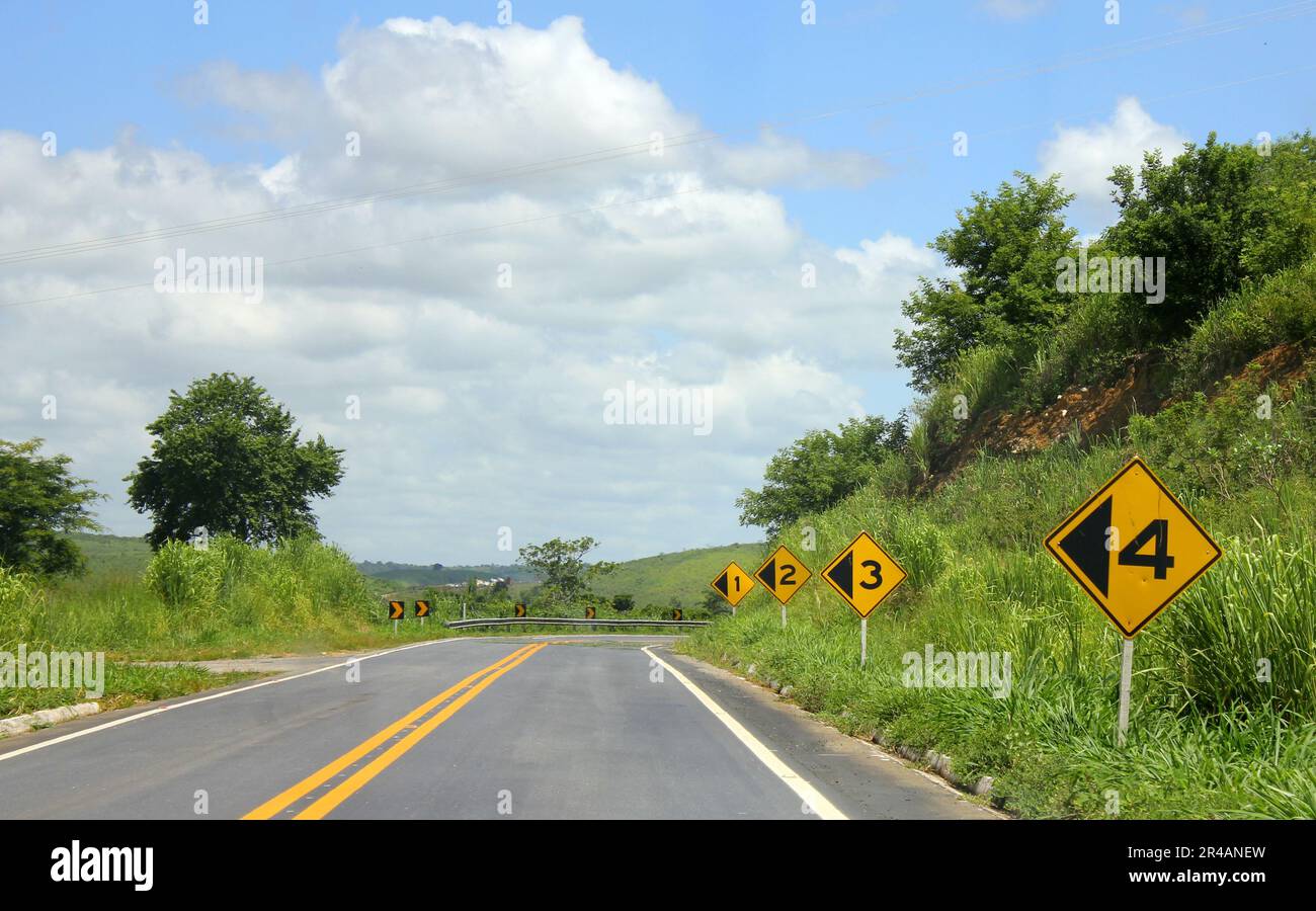 A scenic road in Brazil showcases four successive vertical signs with ...