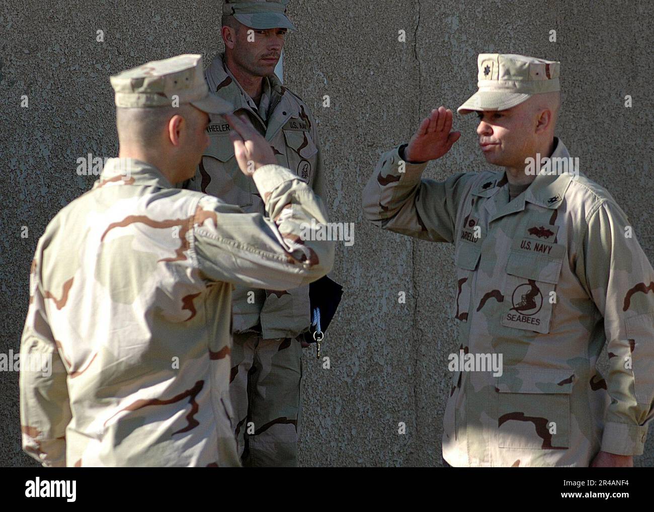 US Navy Cmdr. L. V. Cariello, right, salutes Cmdr. J. W. Korka ...