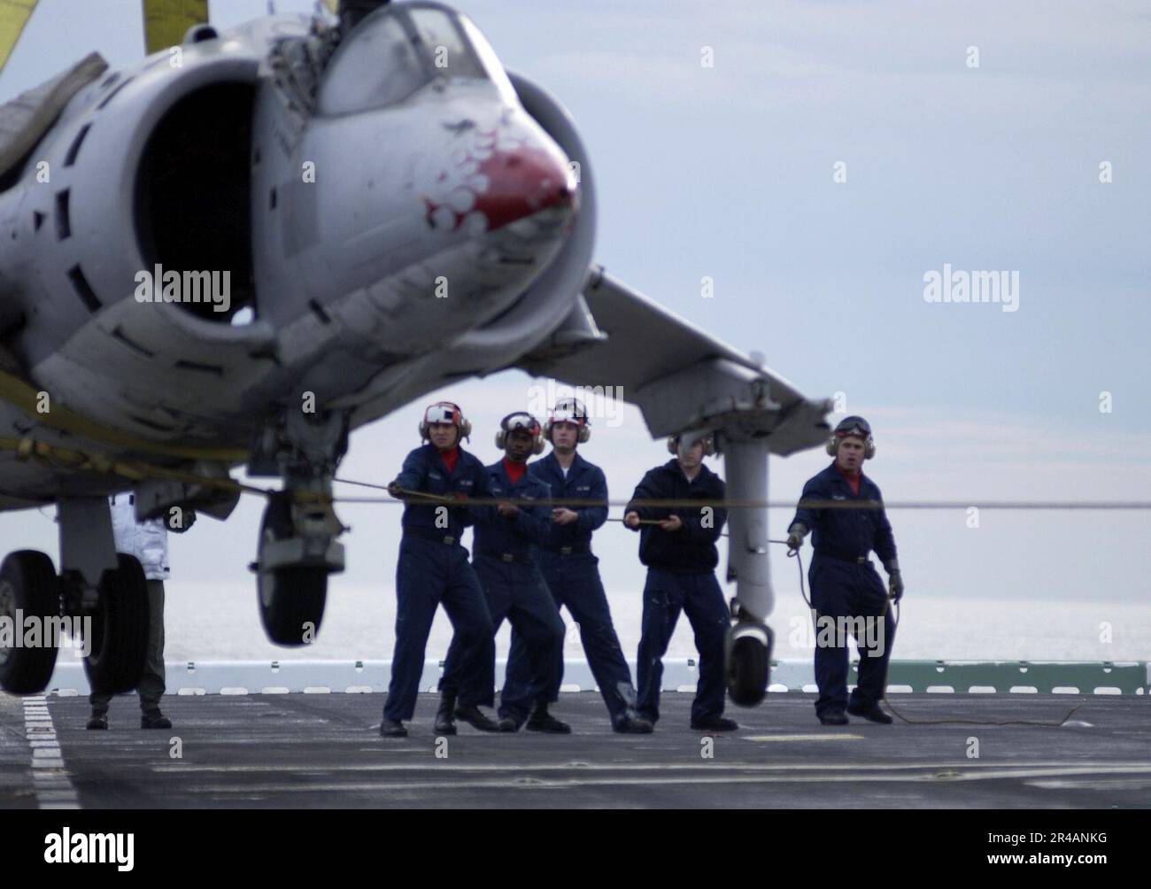 US Navy Aviation Boatswain's Mates work together to provide guidance to ...