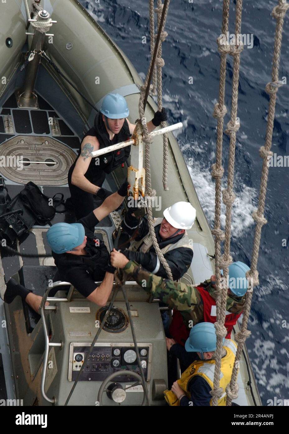US Navy A boat crew attaches a pulley prior to having their Rigid Hull ...