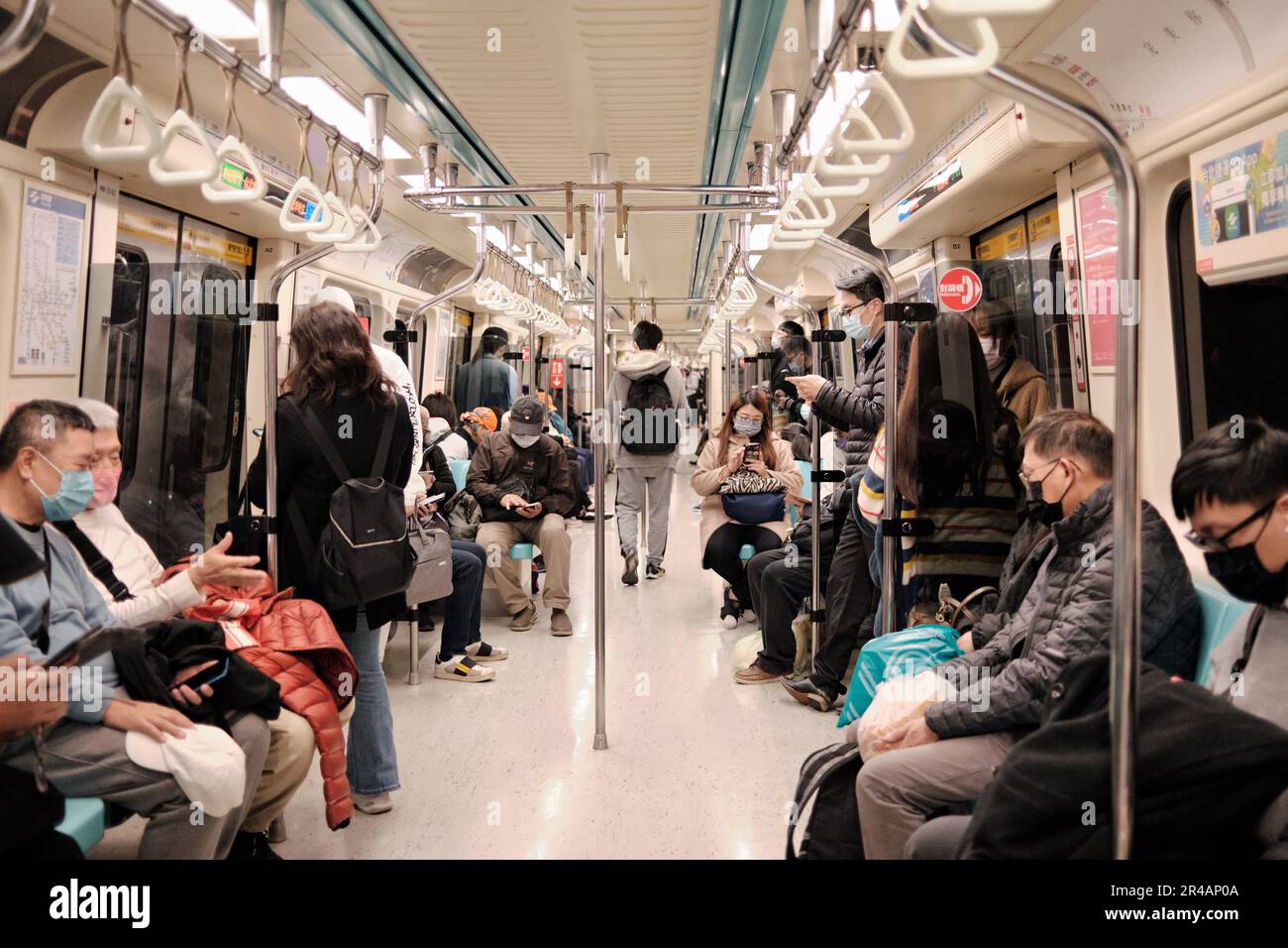 A diverse group of adults are packed together in a public ...