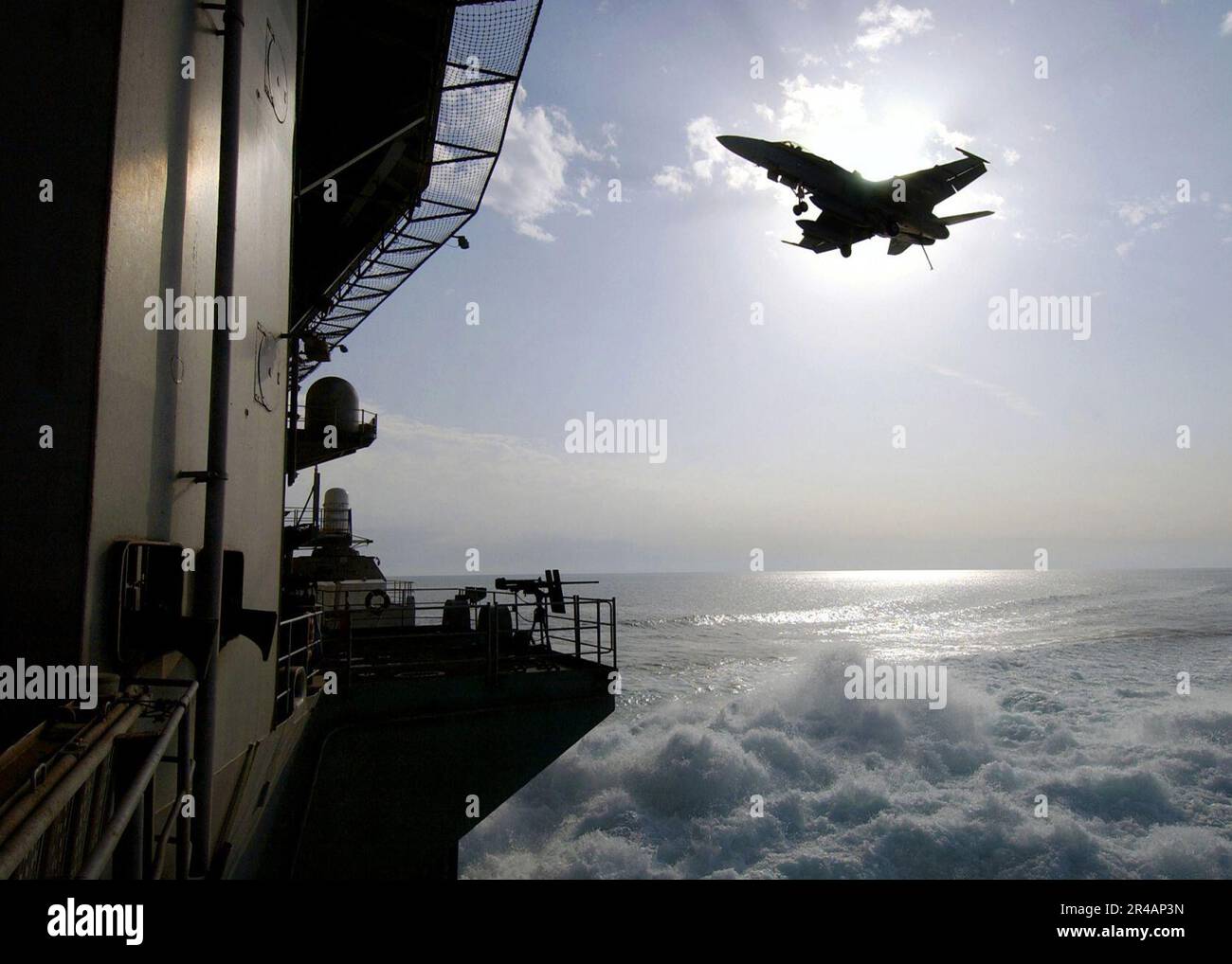 Us Navy An F A 18 Hornet Flies Over The Churning Wake Produced By The
