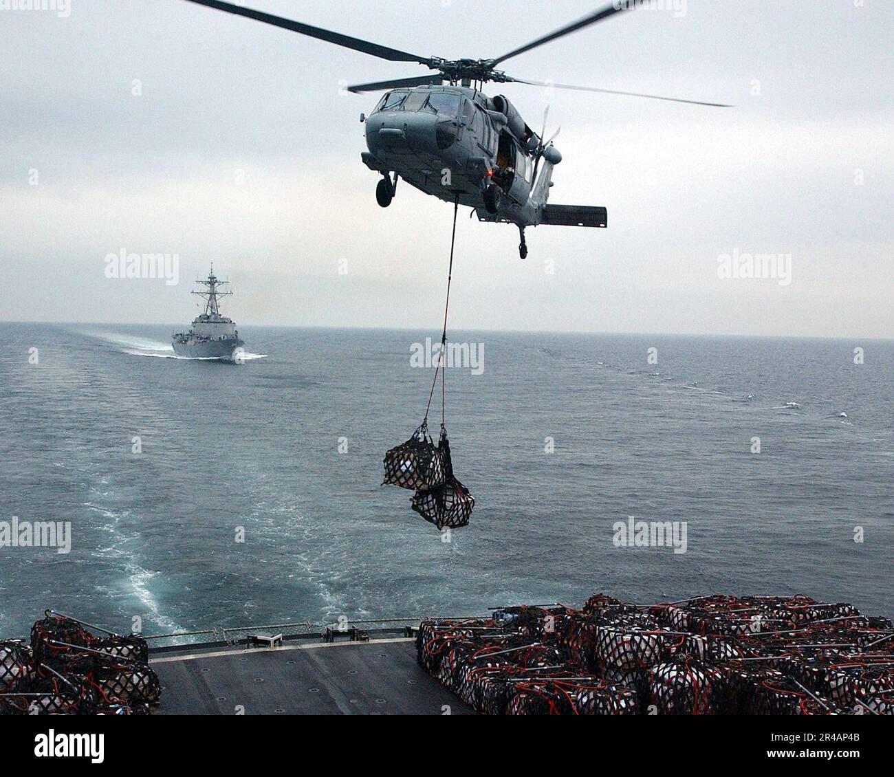 US Navy An MH-60S Seahawk helicopter lifts two pallets of supplies from ...