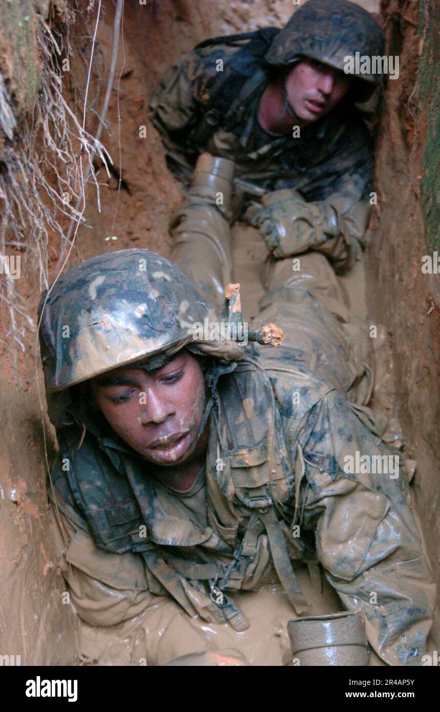 US Navy U. S. Marines low-crawl through muddy trenches during the ...