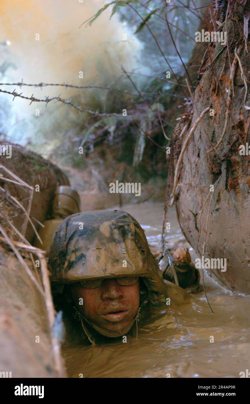 US Navy A U.S. Marine low-crawls through muddy trenches during the ...