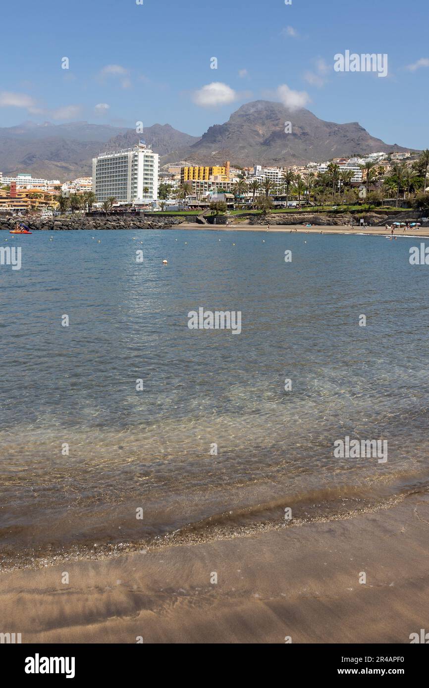 A beachfront town with a rocky cliffside, featuring multiple buildings ...