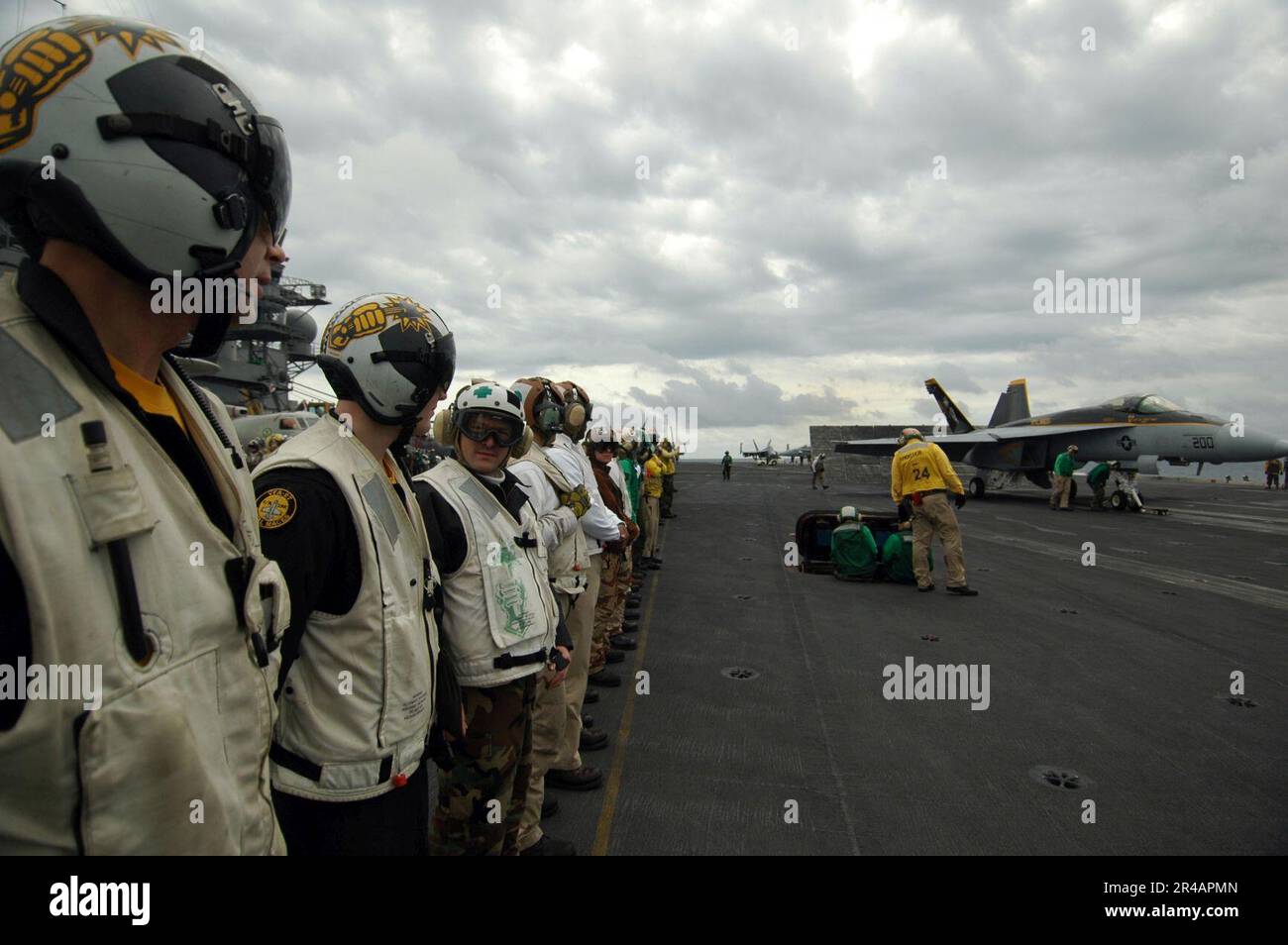 US Navy Officers and Sailors line up on the flight deck to watch their ...
