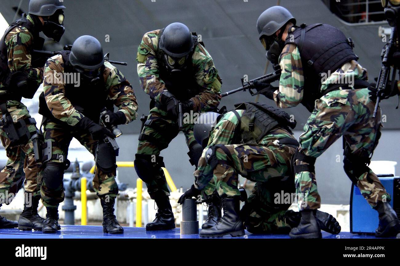 US Navy Explosive Ordinance Disposal team members take part in a scene ...