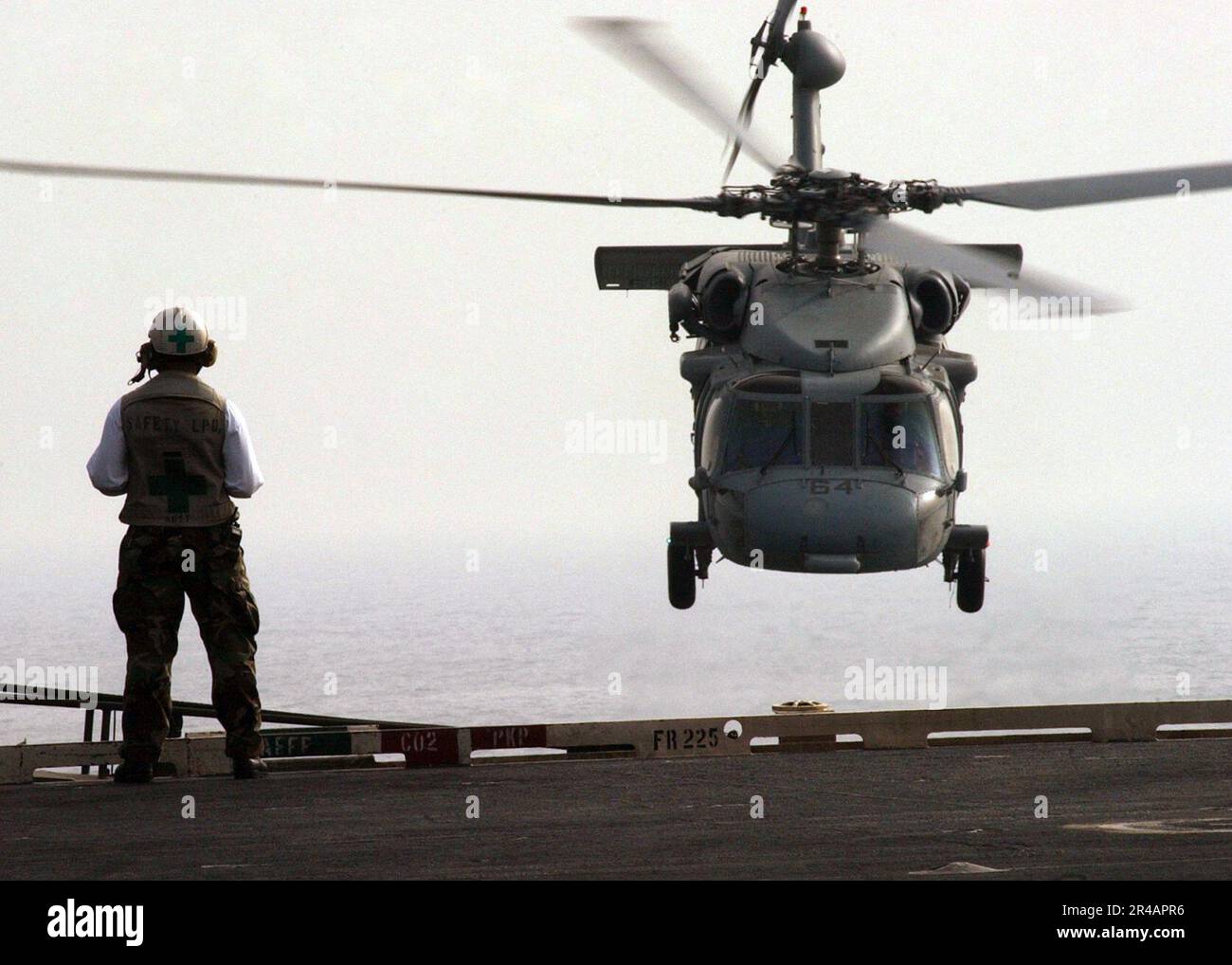 US Navy A Safety Observer watches as an MH-60S Seahawk helicopter ...