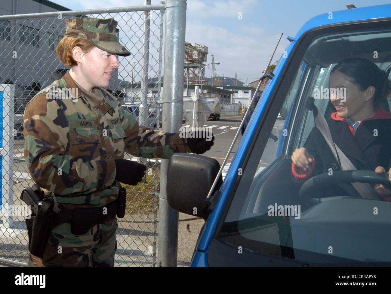 US Navy Master-at-Arms Seaman checks an identification card (ID) before ...