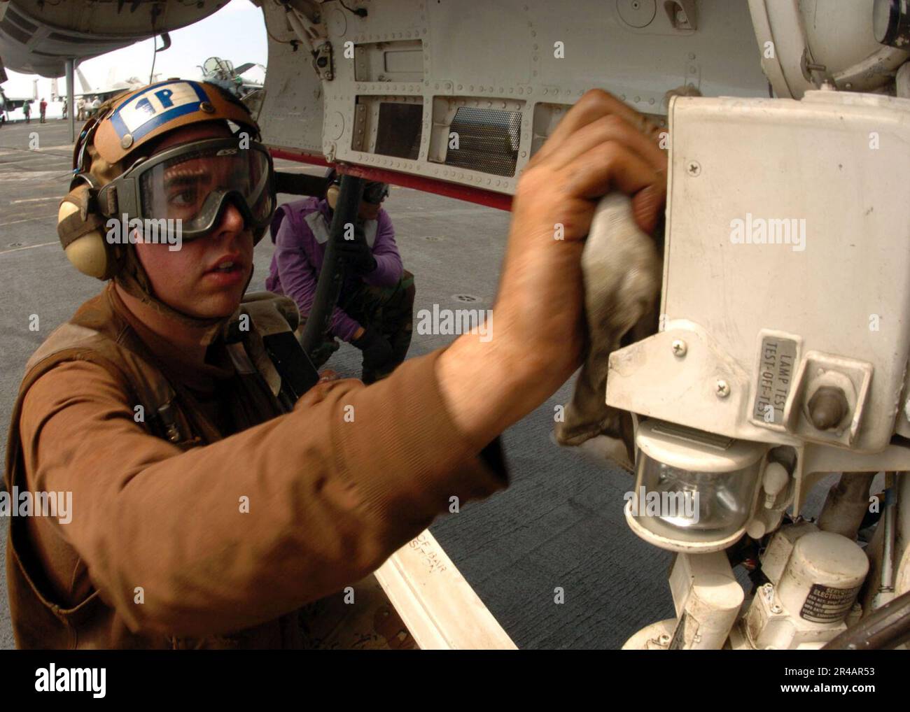 US Navy Aviation Structural Mechanic Airman cleans the approach lights ...