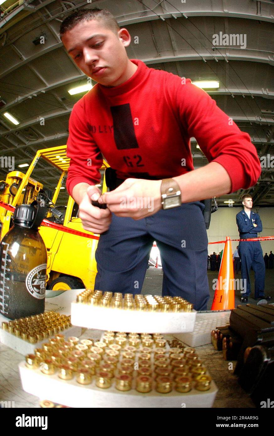US Navy Airman Recruit loads 9mm rounds into a clip during preparations ...
