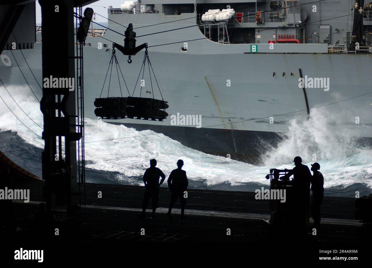 US Navy Aviation Ordnancemen stand by to receive a pallet of ordnance ...