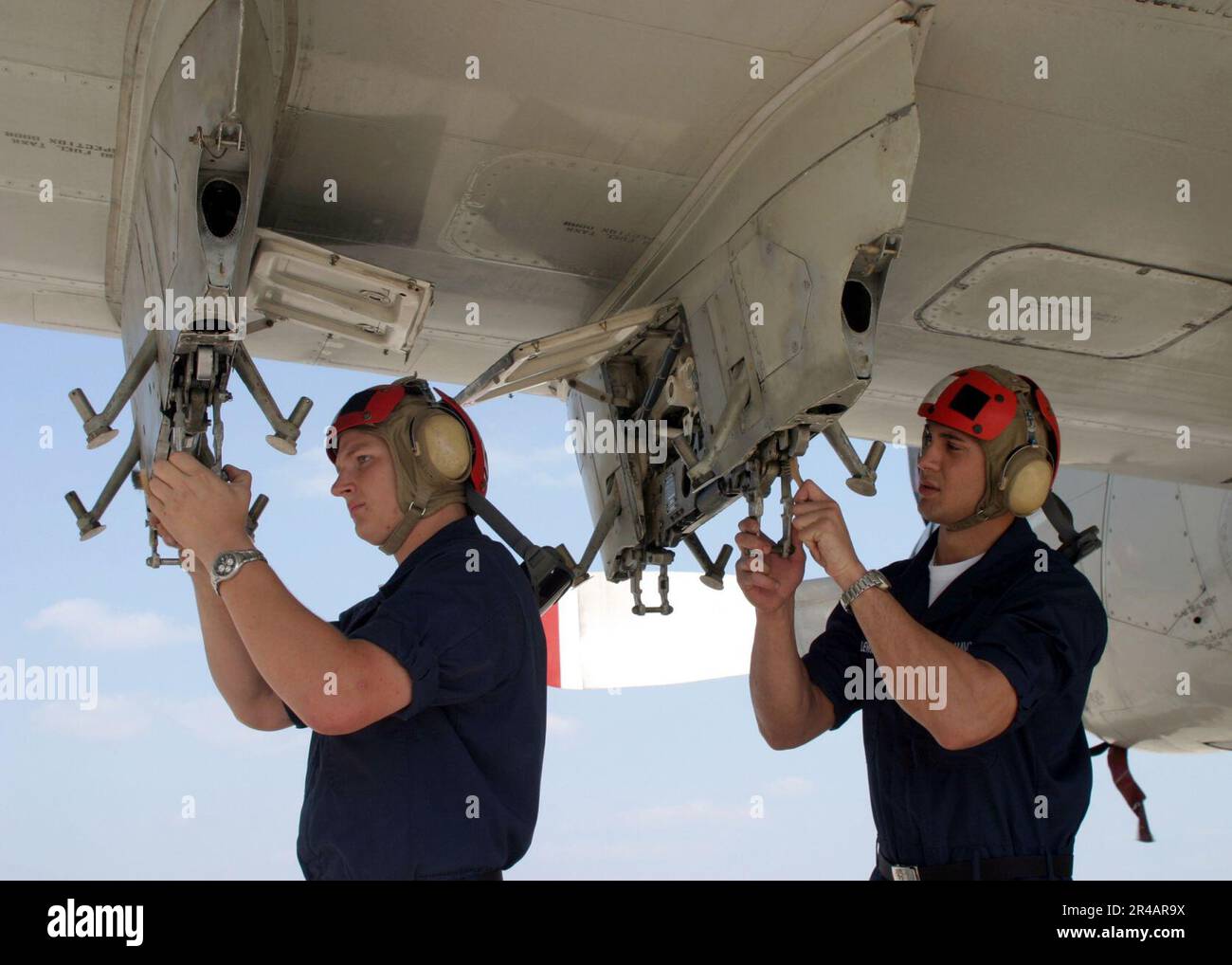 US Navy Aviation Ordnanceman Airman clean bomb racks on a P-3C Orion ...