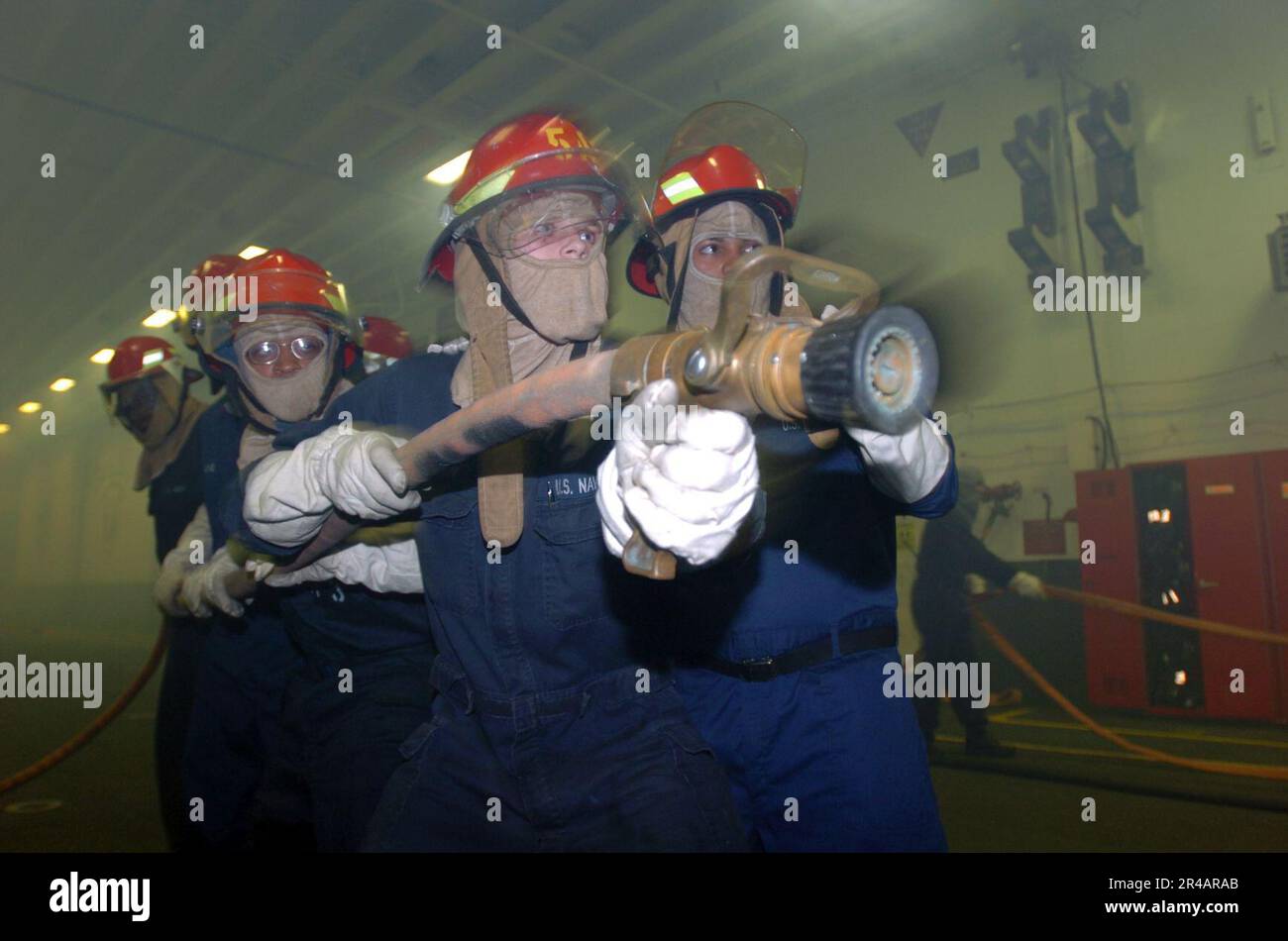 US Navy A fire fighting team works together to put out a simulated fire ...