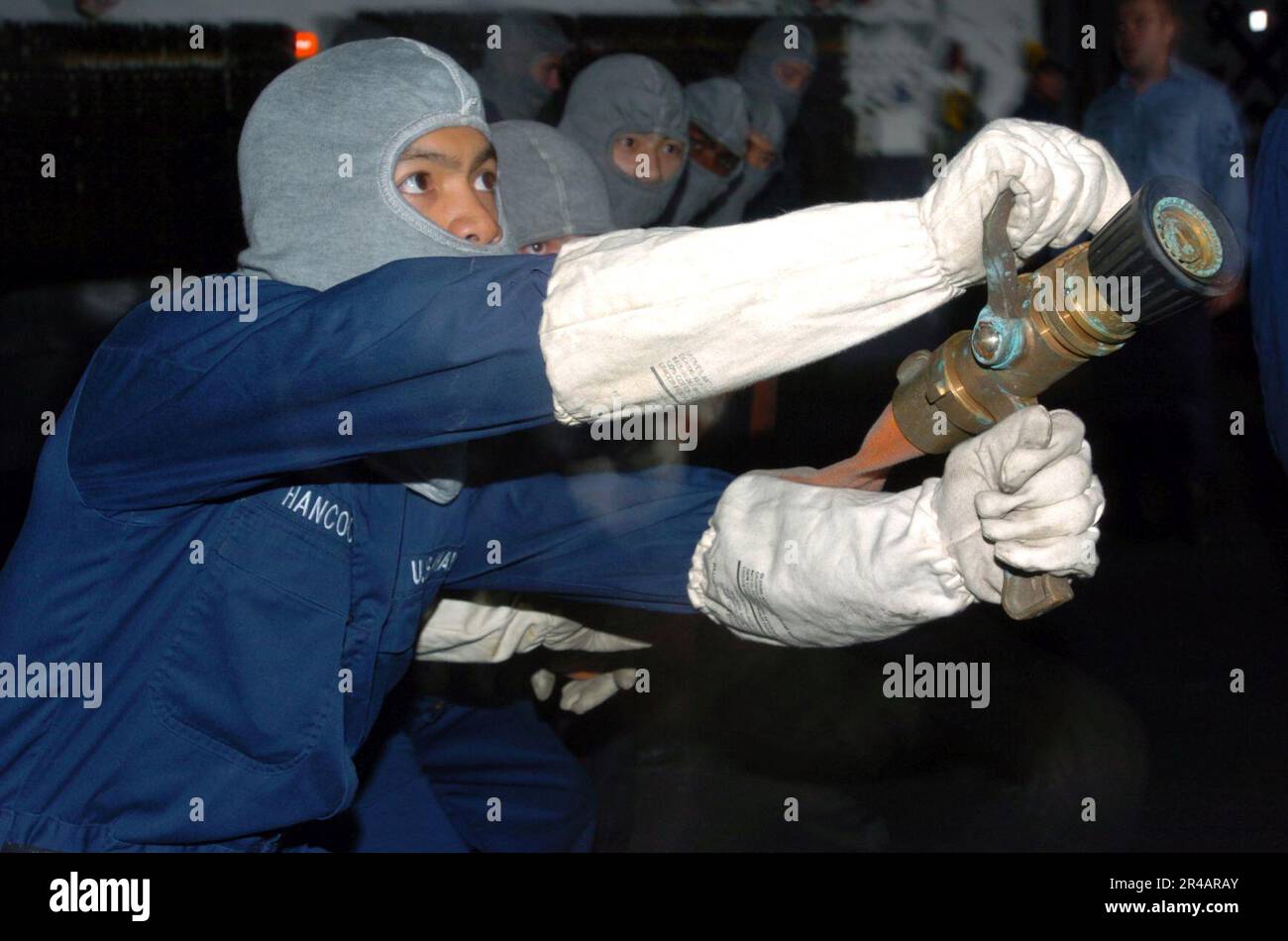 US Navy Electrician's Mate Fireman Apprentice sways the nozzle of a ...
