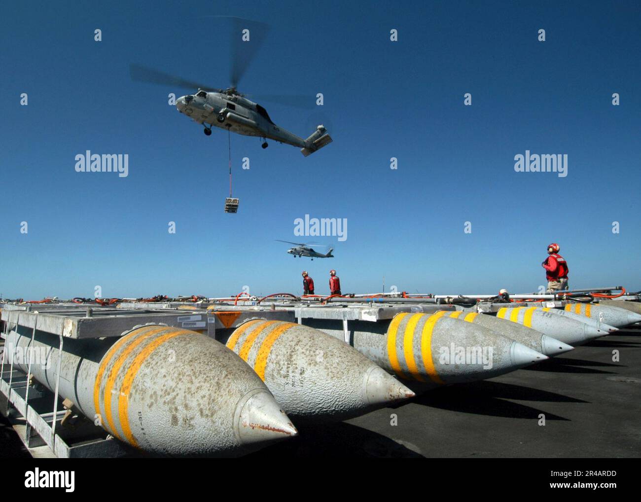 US Navy An SH-60F Seahawk helicopter lifts a pallet of ordnance from ...