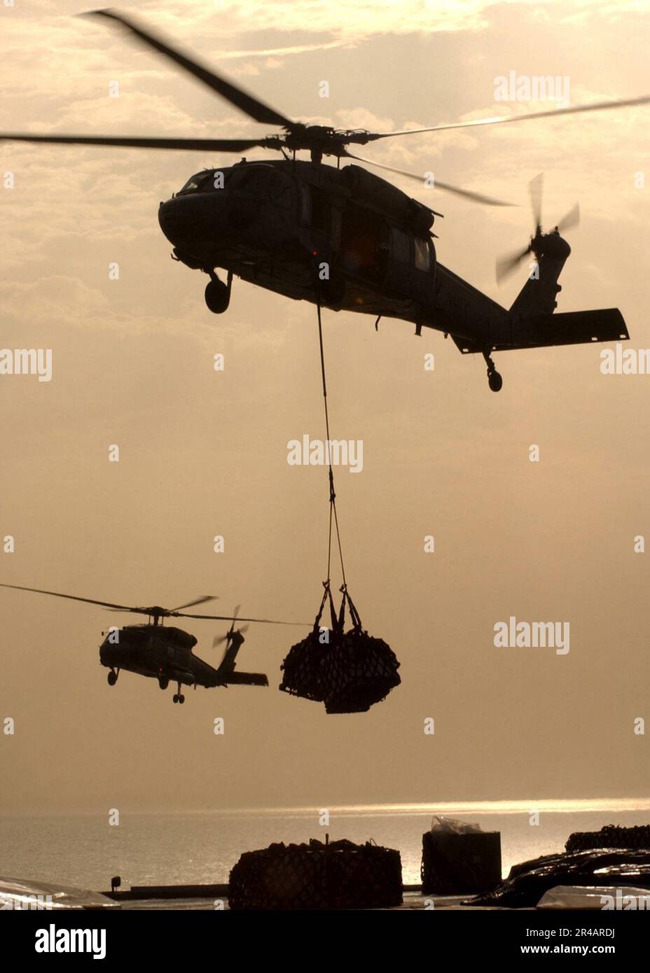 US Navy Two MH-60S Seahawk helicopters transfer stores from the ...