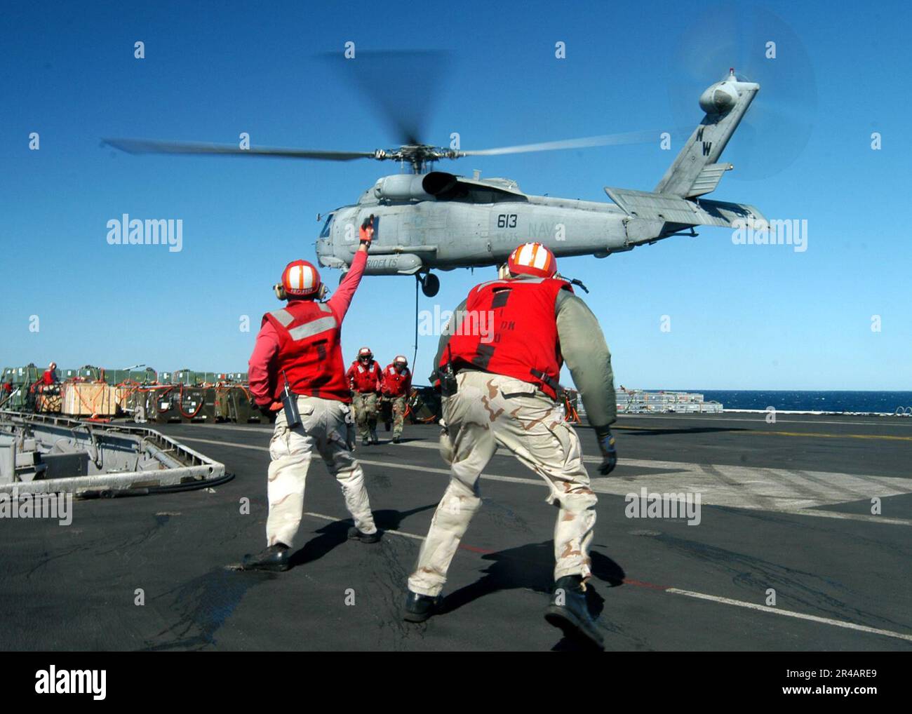 US Navy Chief Warrant Officer 4th Class signals to an SH-60B Seahawk to ...