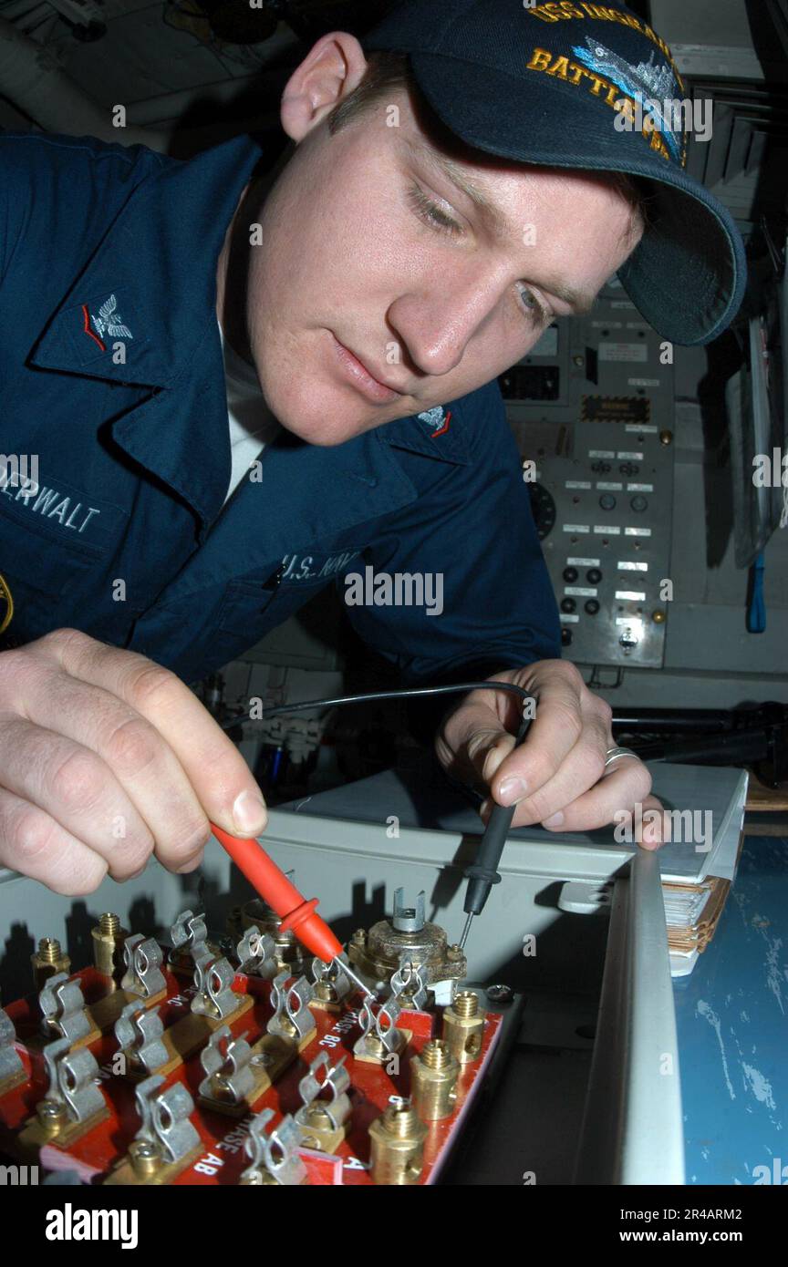 US Navy Electrician's Mate 3rd Class troubleshoots a fuse box with a ...
