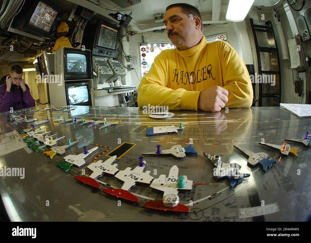 US Navy Flight Deck Handler, Lt. Cmdr. looks over the Ouija Board, a ...
