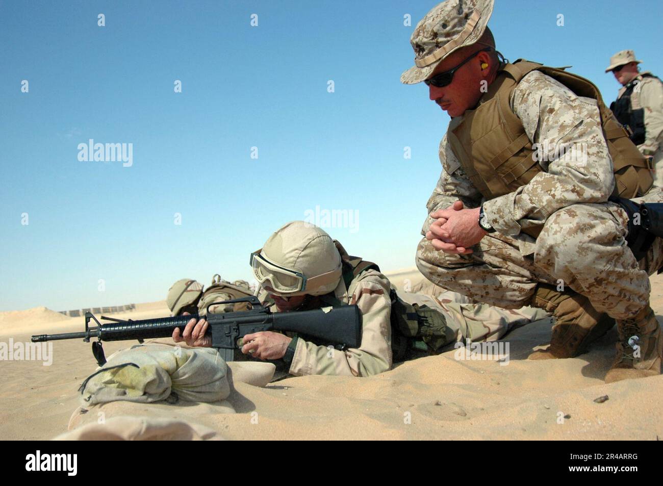 US Navy Gunnery Sgt. supervises a U.S. Navy Seabee during a live-fire ...