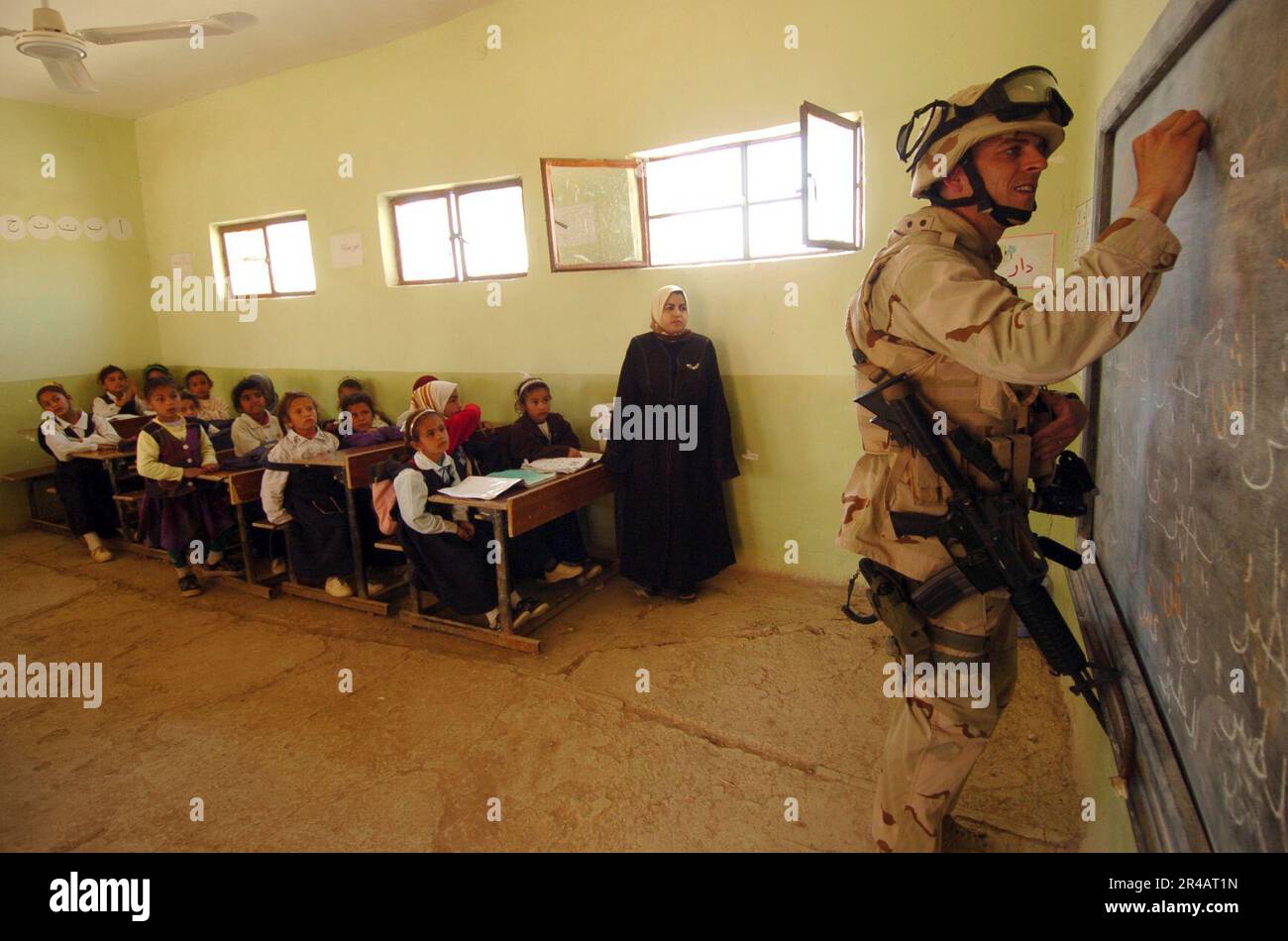 US Navy Photographer's Mate 1st Class draws a picture on a chalkboard ...