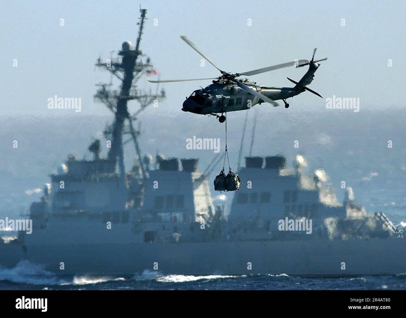 US Navy A MH-60S Seahawk helicopter flies near the Arleigh Burke-class ...