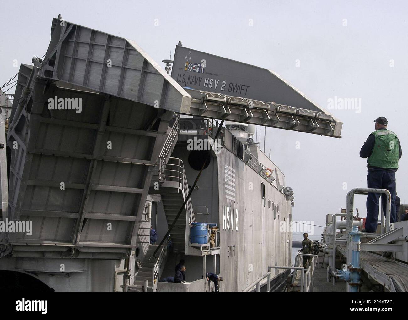 US Navy Chief Boatswain's Mate directs the lowering of the rear ramp of ...