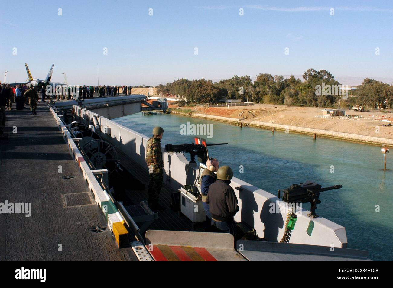 US Navy Sailors on the flight deck enjoy the view as security personnel ...